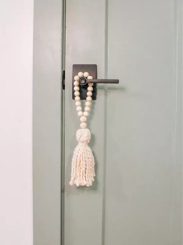 Perlen, die an einem Türknauf hängen; grüne Tür.