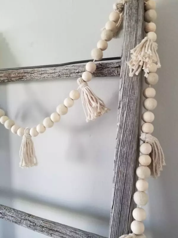 Perlen, die von einer grauen dekorativen Leiter hängen