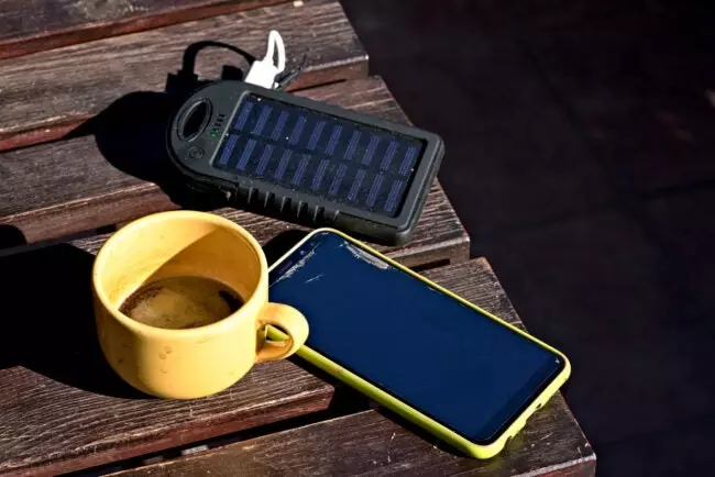 smartphone, powerbank och en kopp kaffe på verandan