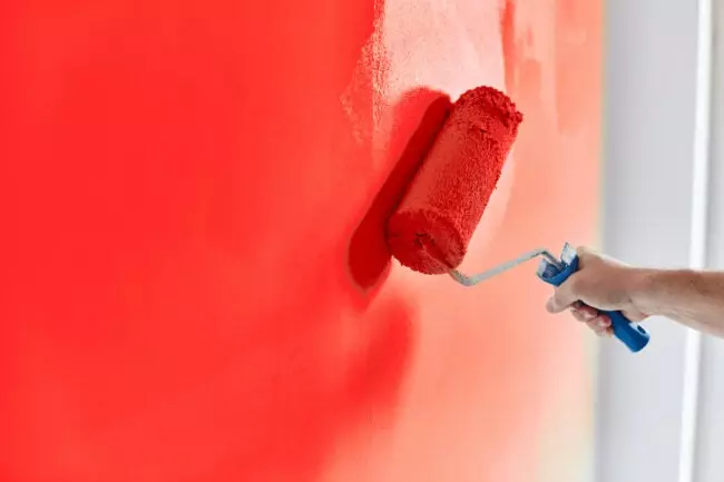 raudonas dažų volelis su šlapiu dažų kraštu
