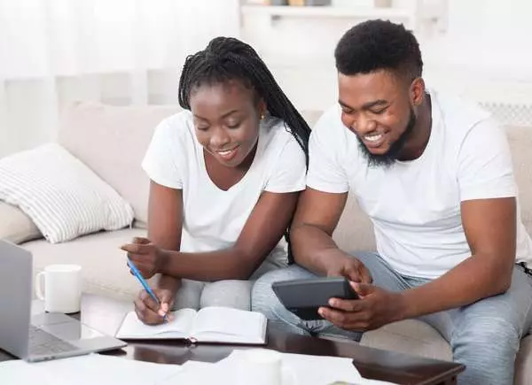 Pareja mirando documentos frente a una computadora