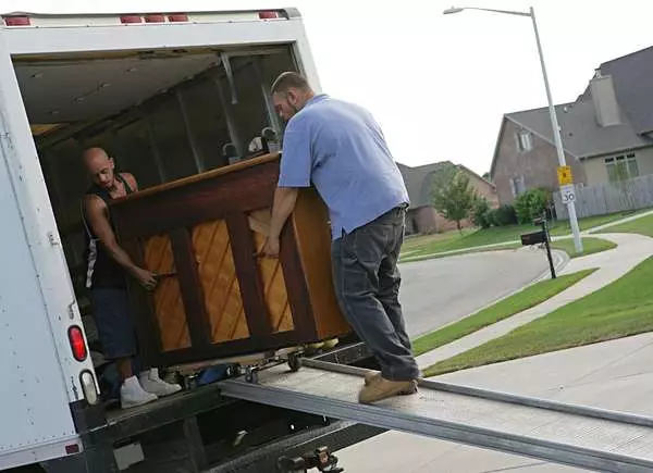 Dos hombres moviendo un piano