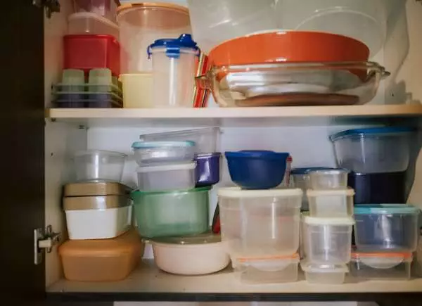 Envases de plástico para almacenar alimentos metidos nunha despensa