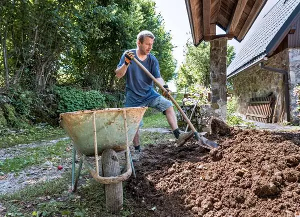 Mann schaaft Dreck aus sengem Haff