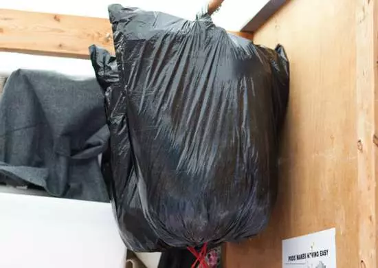 Empaquetar la roba penjada a les bosses d'escombraries